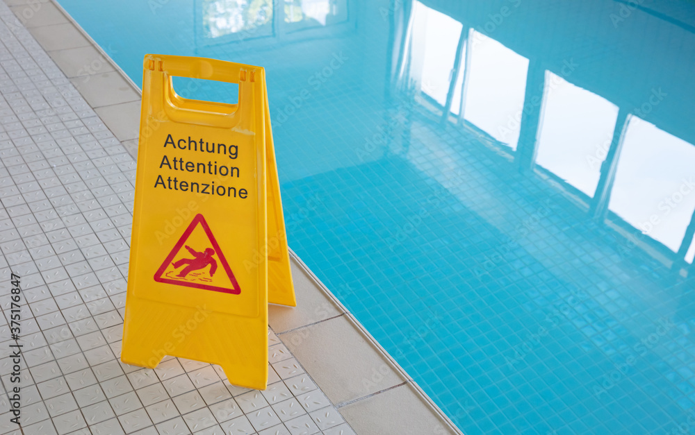 Wet floor sign by indoor swimming pool Stock Photo | Adobe Stock