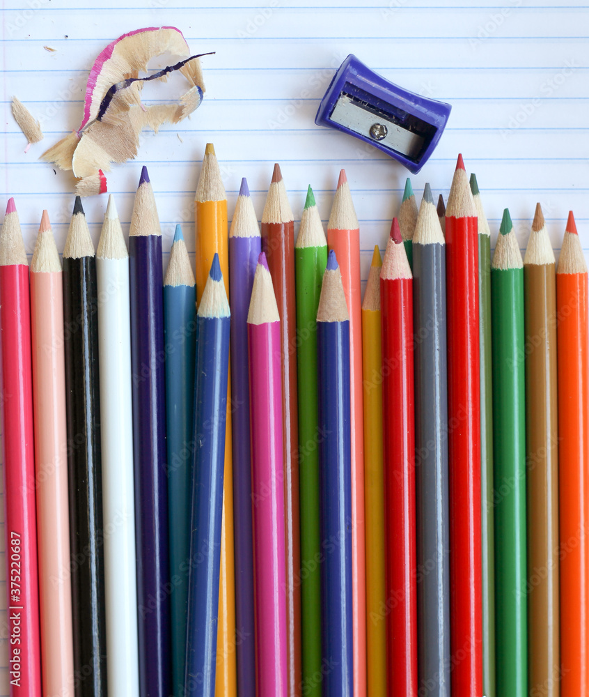 Sharp colored pencils and a sharpener on lined paper Stock Photo ...
