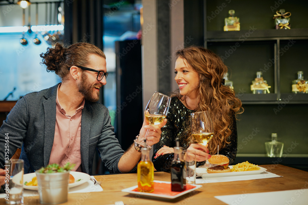 Cheerful couple in love sitting in restaurant, having diner and ...