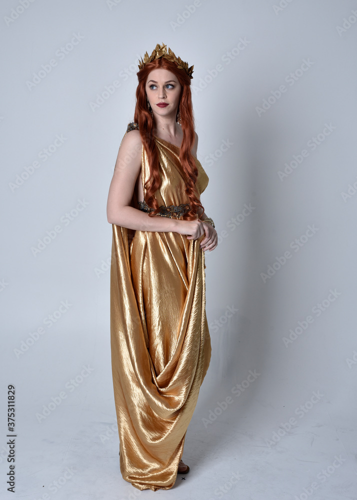 Full length portrait of girl with red hair wearing long grecian toga ...