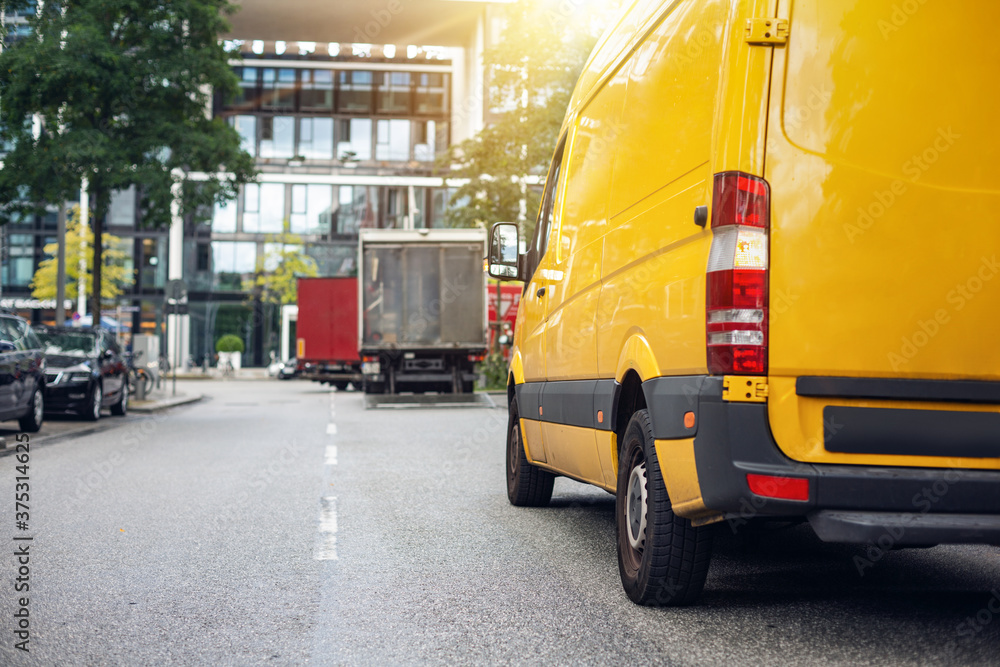 Yellow delivery van on a street inside a city Stock Photo | Adobe Stock