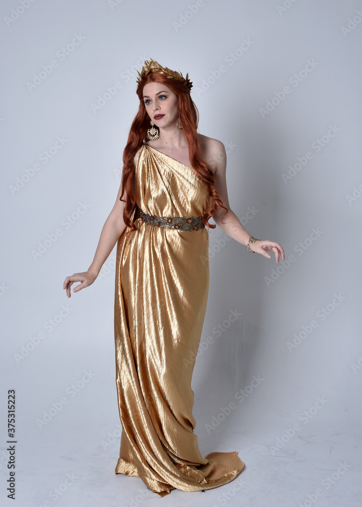 Full length portrait of girl with red hair wearing long grecian toga ...