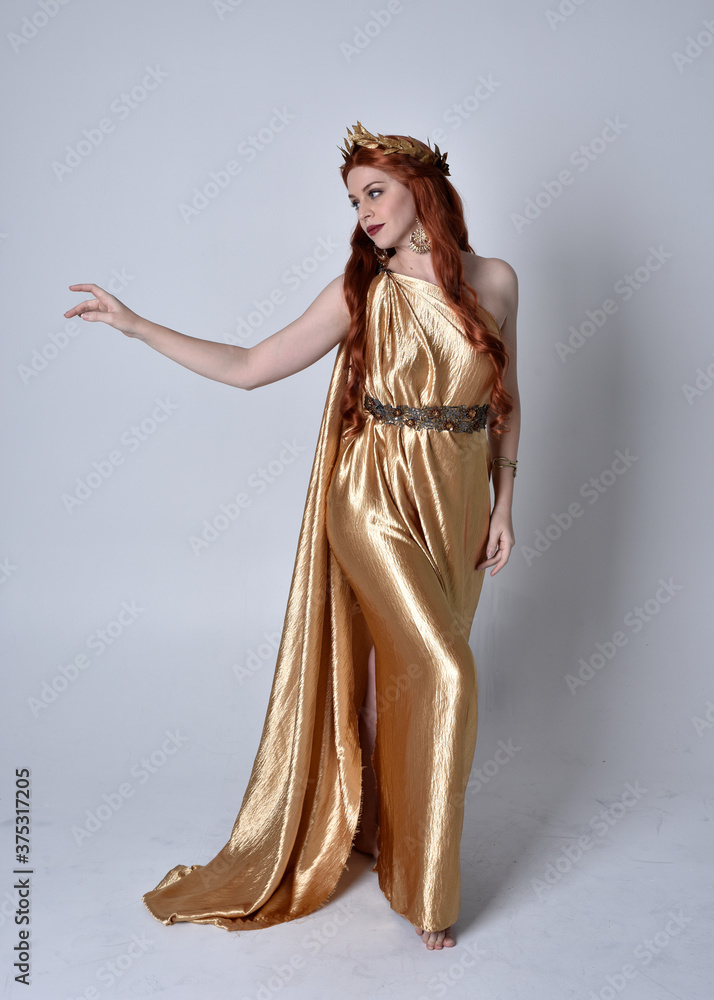 Full length portrait of girl with red hair wearing long grecian toga ...