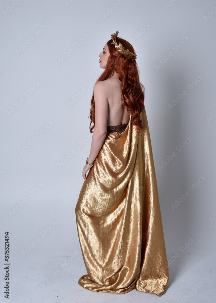 Full length portrait of girl with red hair wearing long grecian toga ...