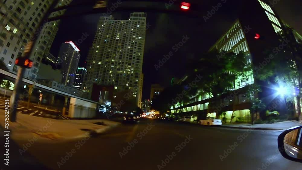 MIAMI, FL - FEBRUARY 2012: Driving along city road at night, view from ...
