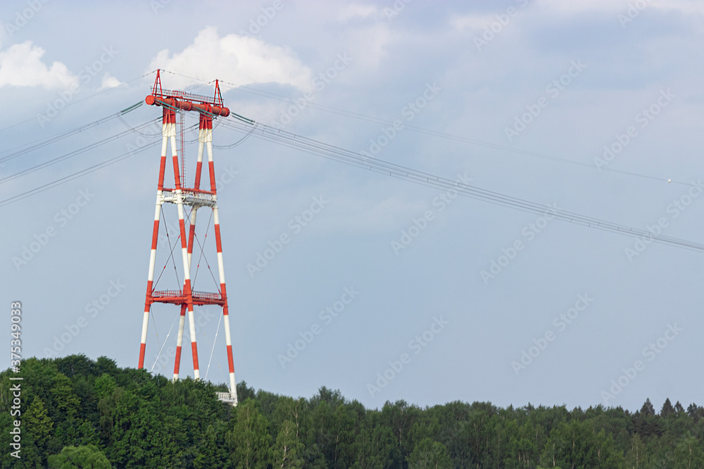 Big red-white High voltage tower over the forest. electricity pylons ...