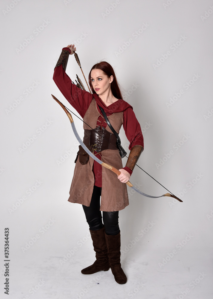 Full length portrait of girl with red hair wearing brown medieval ...