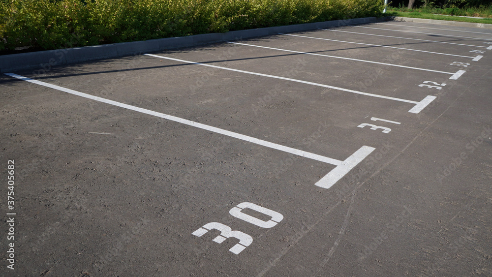 Close-up of a white paint number marking in a parking lot. Empty ...