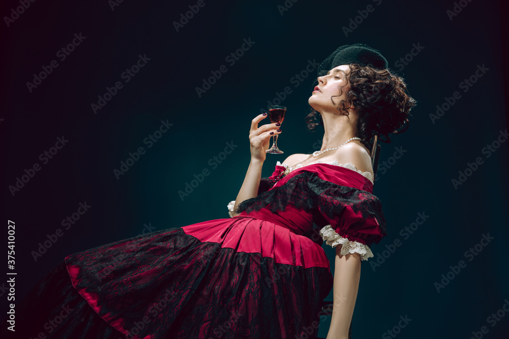 Alcohol. Young woman as Anna Karenina isolated on dark blue background ...
