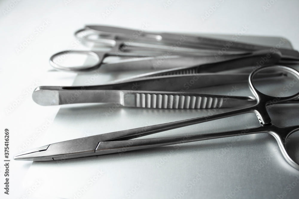 Surgical instruments on metal tray. Scalpel, clamp, scissors, surgical ...
