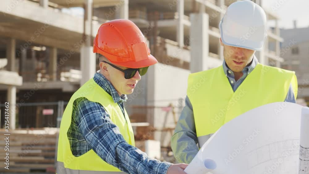 Professional builders standing in front of construction site. Office ...