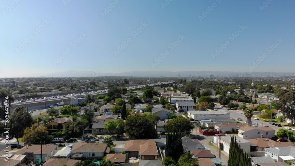 Aerial slowly flying over neighborhood overlooking traffic on ...