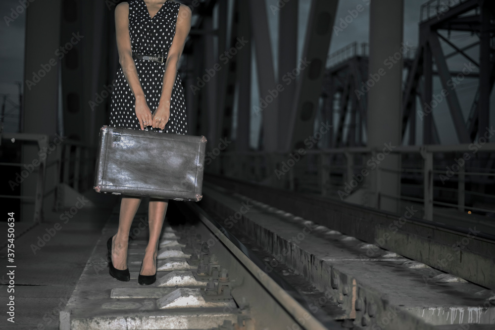 alone Young slim girl with vintage suitcase at railways. no face. night ...