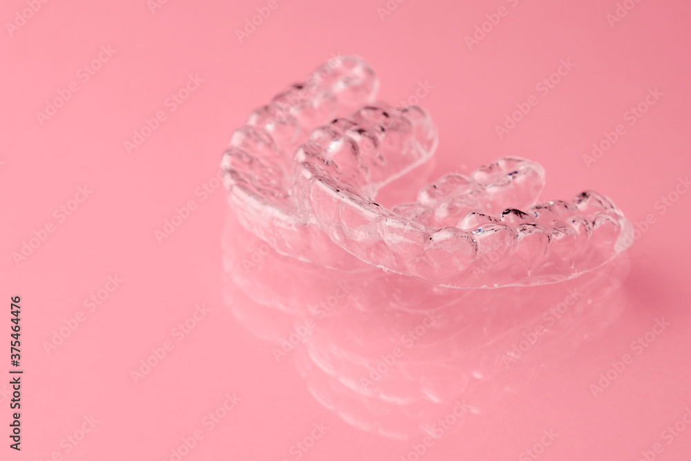 Two Invisible dental teeth aligners on the pink background. Orthodontic ...