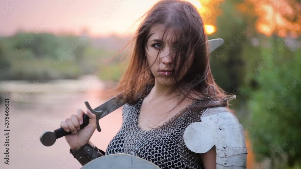 Camera movement from bottom to top, medieval woman warrior in chain mail armor with a shield and ...