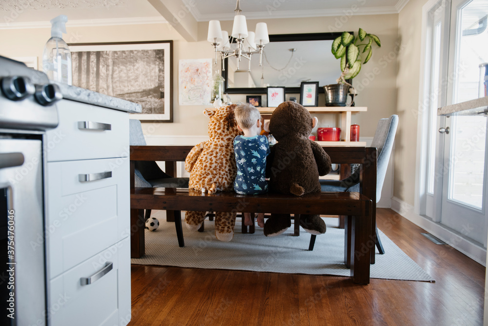 Young boy on bench with large soft toys Stock Photo | Adobe Stock