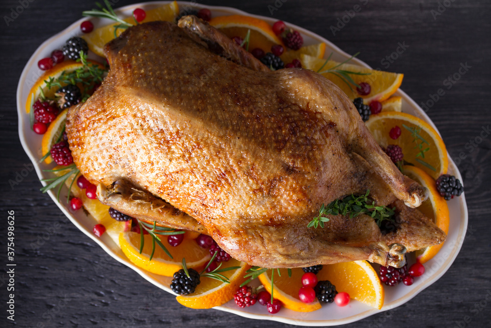 Whole roasted duck with oranges, berries and herbs. Christmas dinner ...