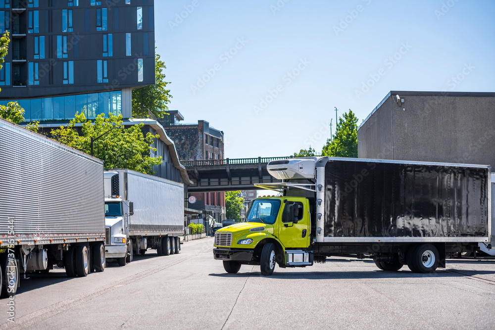 Medium-sized rig semi truck with refrigerated box trailer turns on the ...