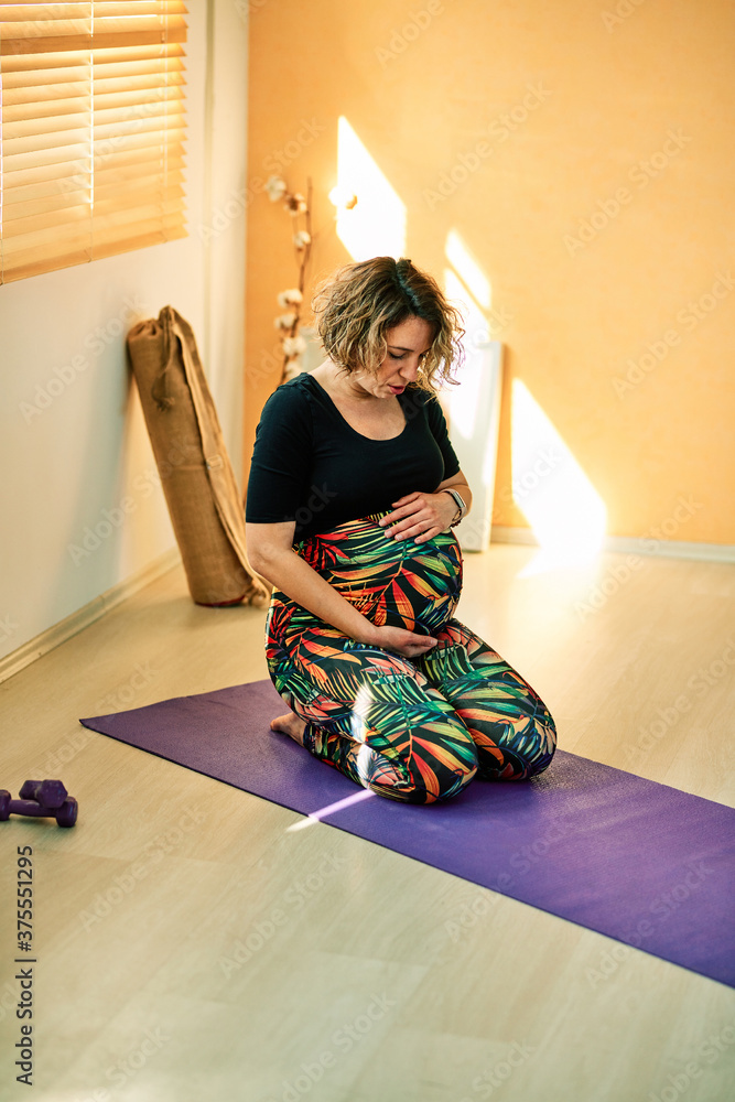 Middle-aged attractive fit pregnant woman sitting in diamond yoga ...
