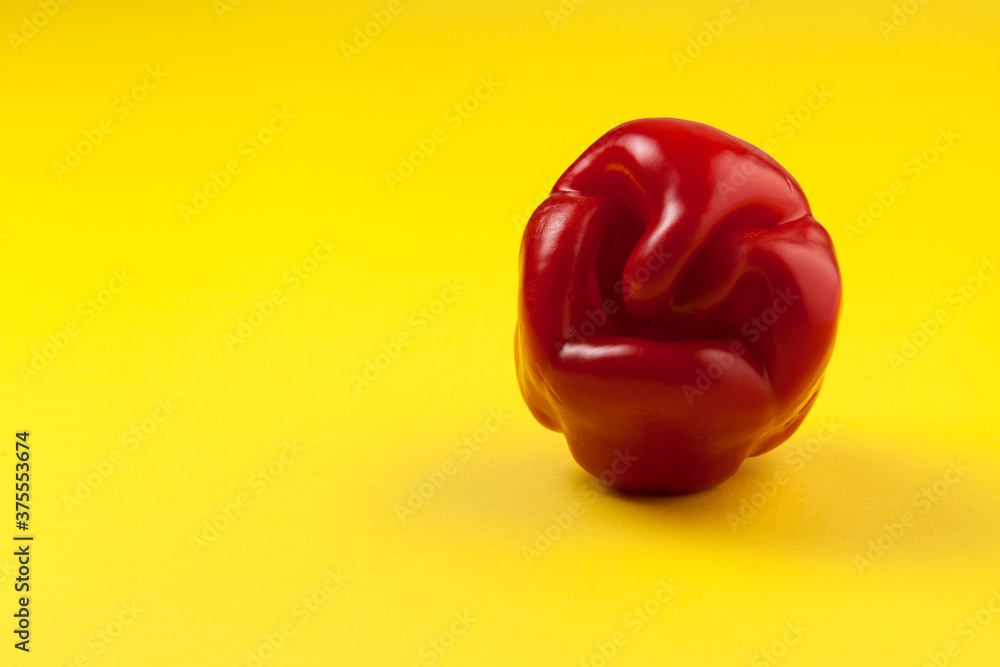 Ugly red bell pepper on yellow background with copy space. Concept ...