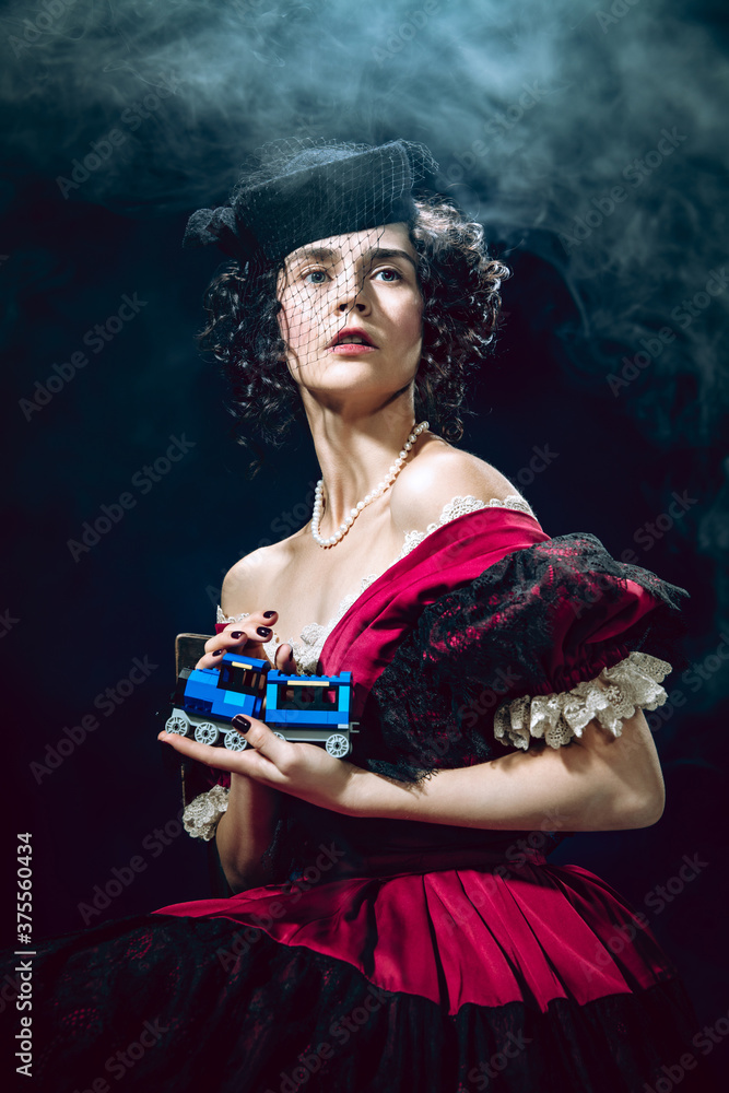 Train station. Young woman as Anna Karenina isolated on dark blue ...