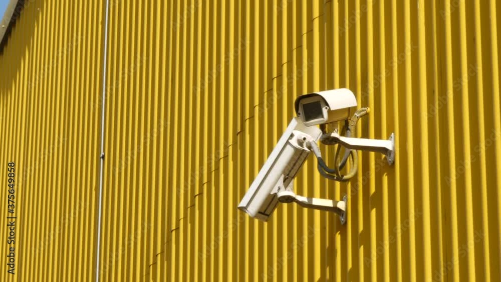 Vidéo Stock CCTV cameras on facade of industrial building on hot summer ...