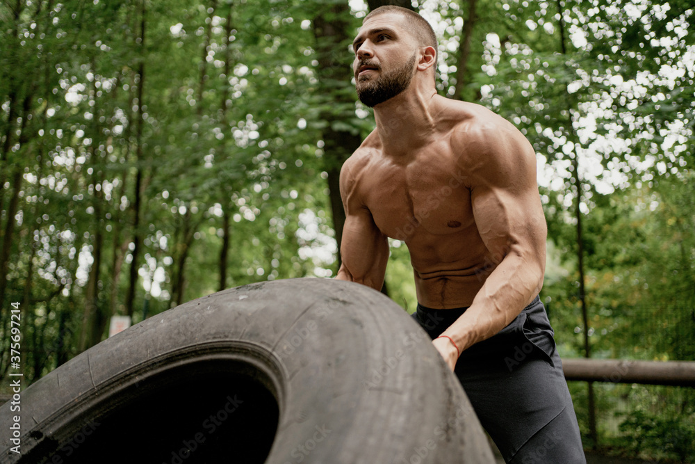 male athlete dark-haired Caucasian appearance, raises the wheel ...