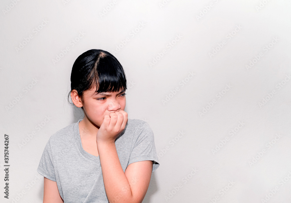 The girl raised her hand over her mouth, showing signs of stress or ...