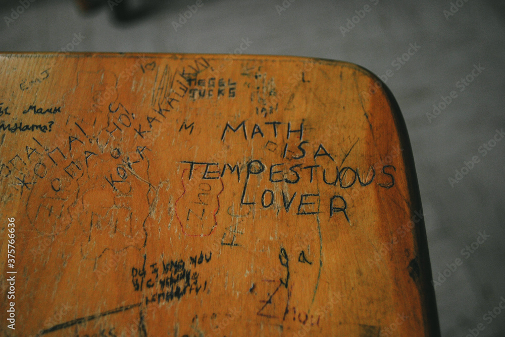 graffiti scratched into school desk top Stock Photo | Adobe Stock