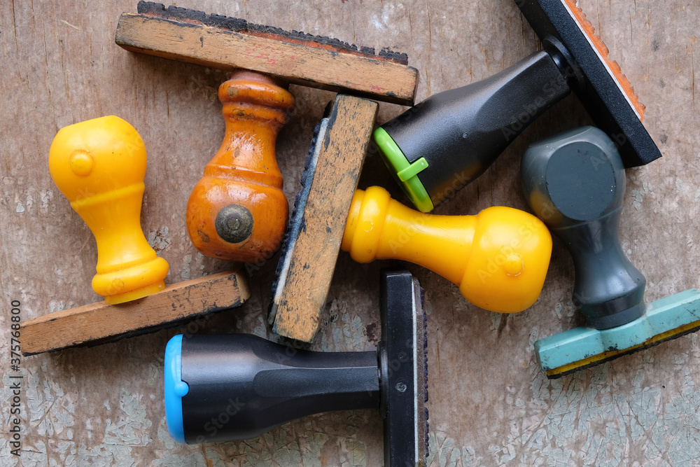 Foto de Various old, used rubber stamps lying on a worn out table ...