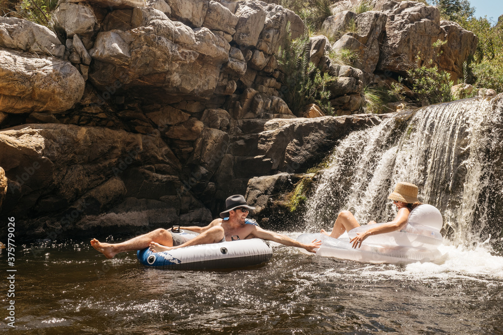 couple floating and playing on inflatable lilo's in a river Stock Photo ...