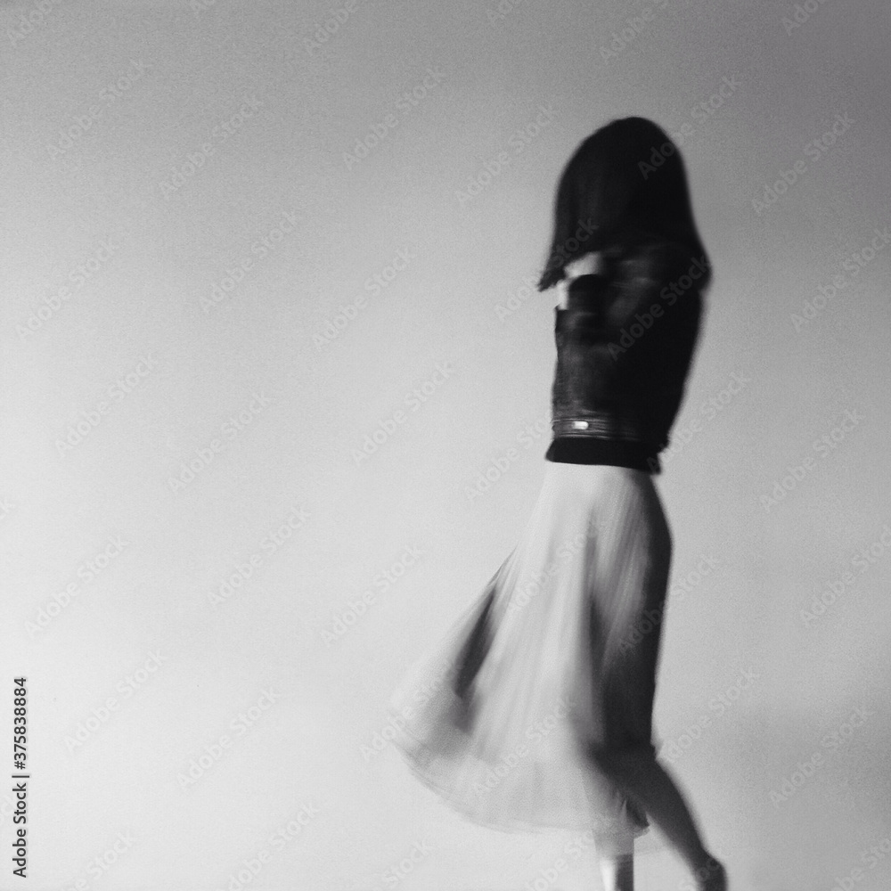 Black and White movement shot of woman wearing a long flowing skirt and ...