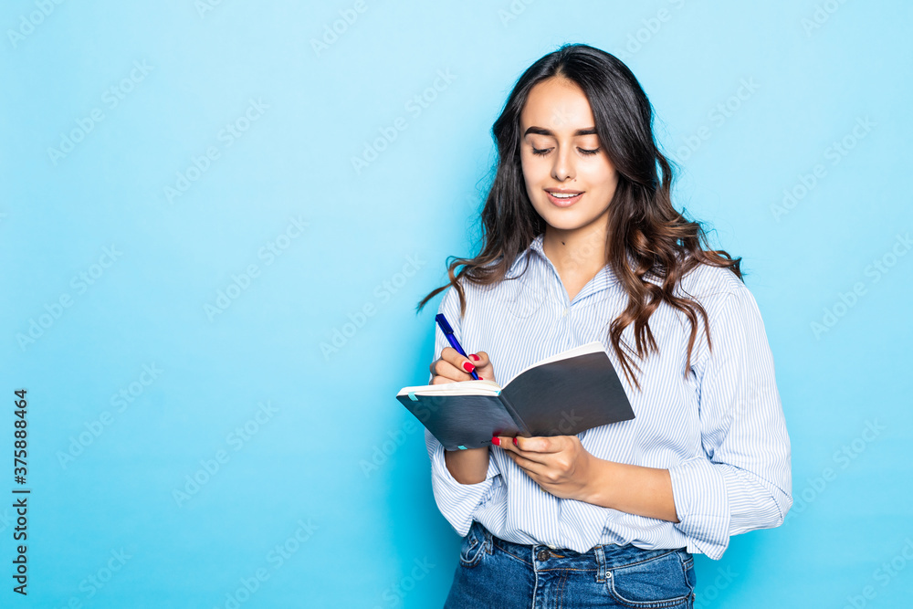 Young girl bought new planner, writing down notes or lecture, smiling ...