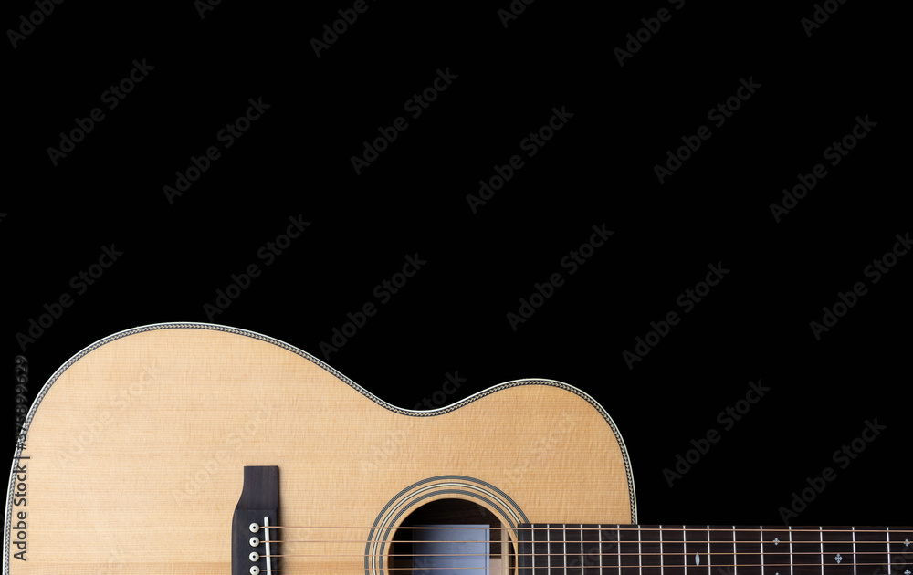 classic steel string acoustic guitar on a black background with copy ...