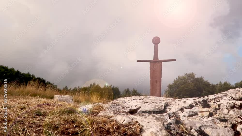 Sword in the stone scenic old rusted in landscape lens flare light ...