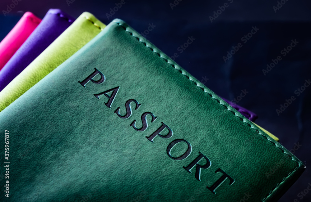 Collection of passports in colorful leather covers on dark background ...