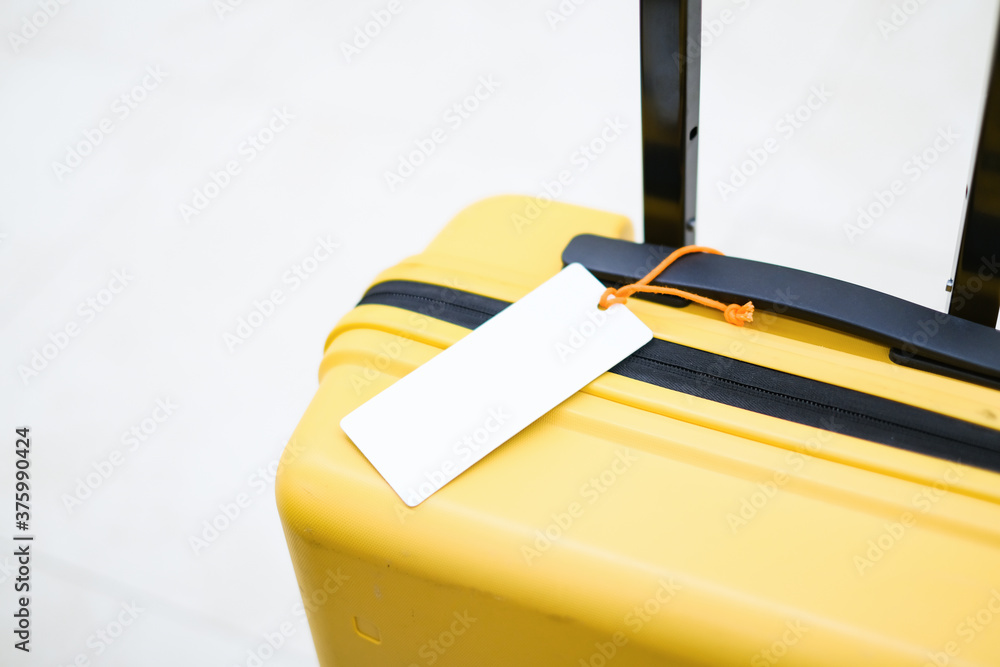 Close up mock up brand tag or name tag tied to yellow thick suitcase ...
