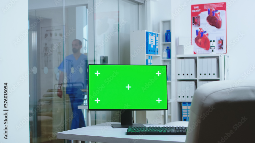 Computer with blank display in hospital cabinet and clinic personnel in ...