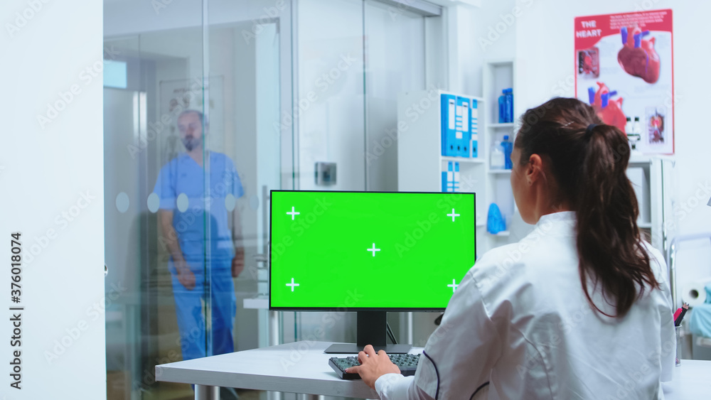 Nurse in blue uniform entering in hospital cabinet while medic is using ...