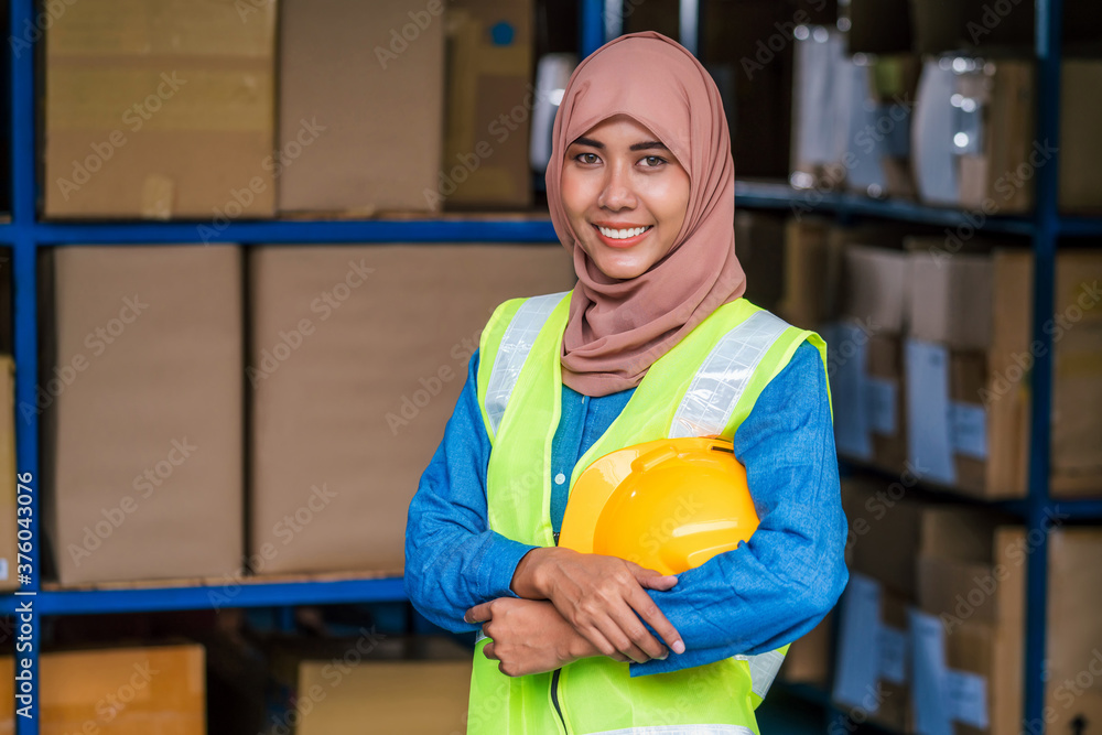Portrait of Muslim worker woman wearing Hijab and standing and holding ...
