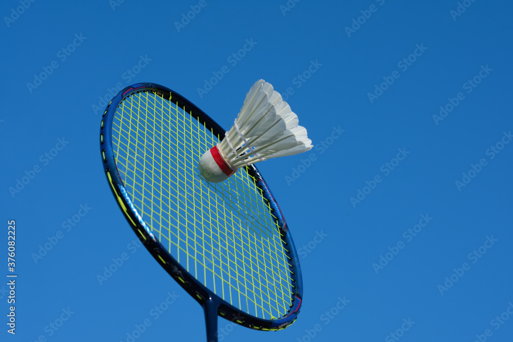Badminton racket hitting shuttlecock on blue sky background. Badminton ...
