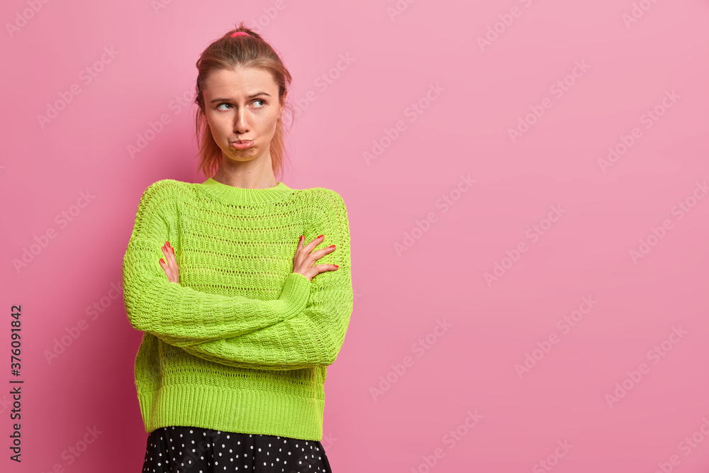 Moody offended woman stands with crossed hands, purses lips, being ...