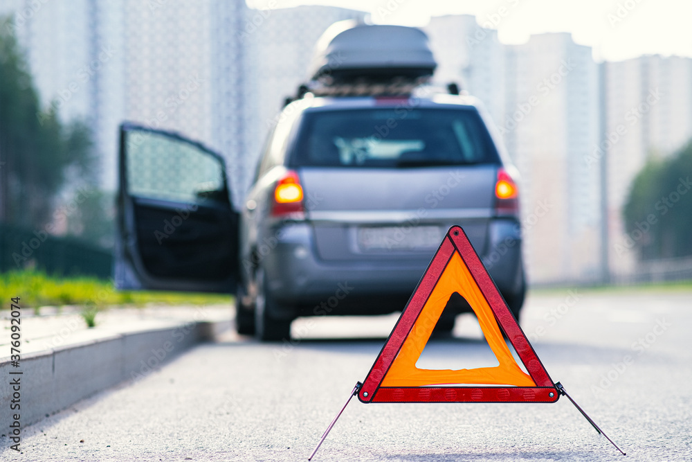 Triangular red retro-reflective sign of accident on the road. Car ...