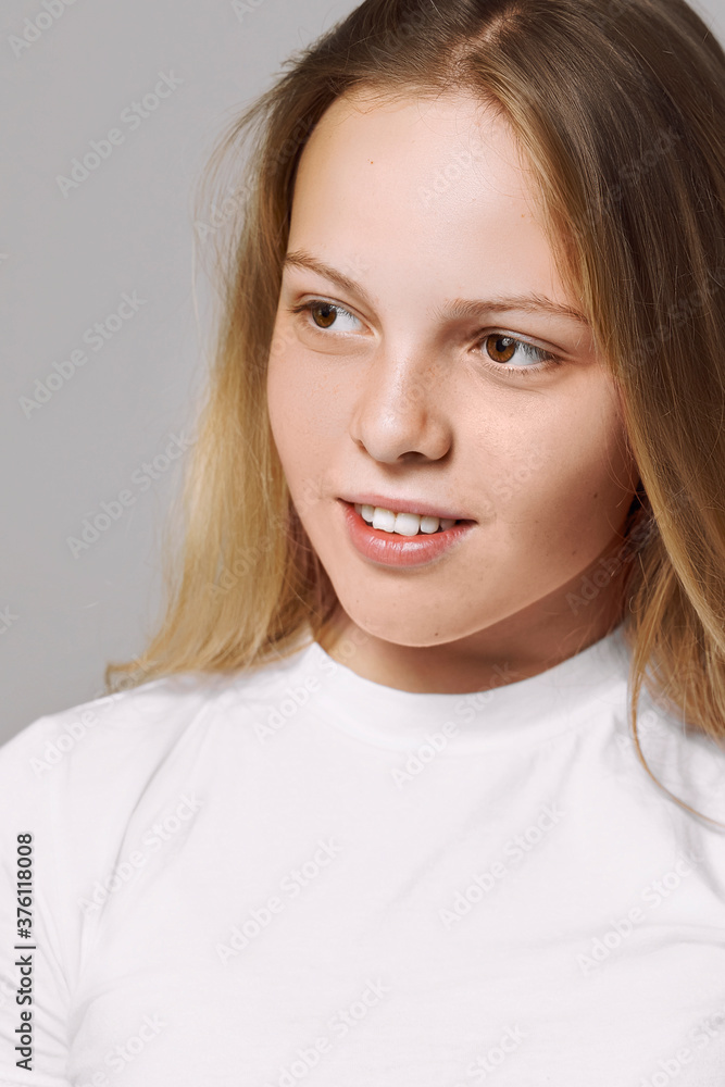 portrait of a beautiful young 16 year old girl in a white t-shirt ...