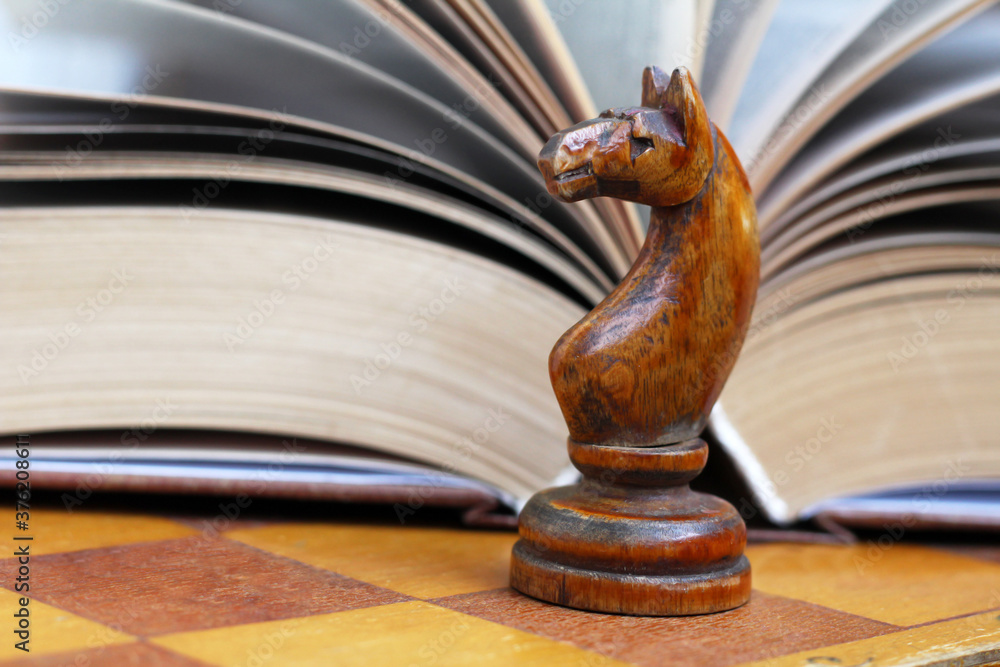 Wooden figure of a horse chess and a book background, retro object ...