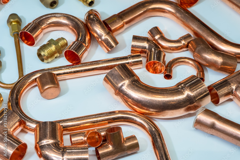 Various parts for copper pipes on table. Couplings and adapters for ...