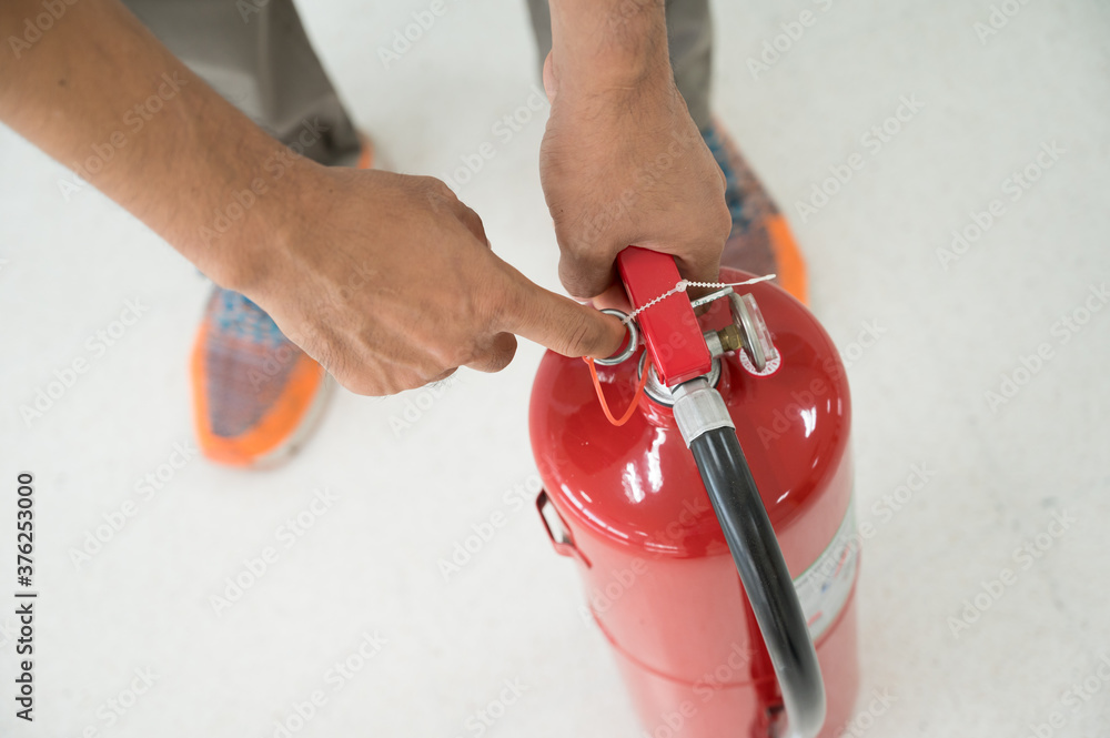 Close up man showing how to use a fire extinguisher on a training fire ...