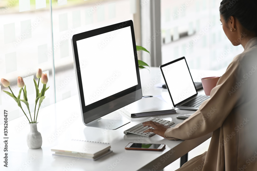 Two screen of computer with businesswoman typing her computer keyboard ...