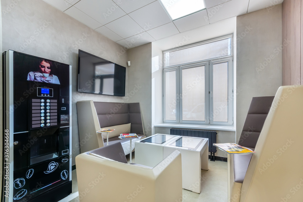 The waiting area in a modern sales office with a vending coffee machine ...