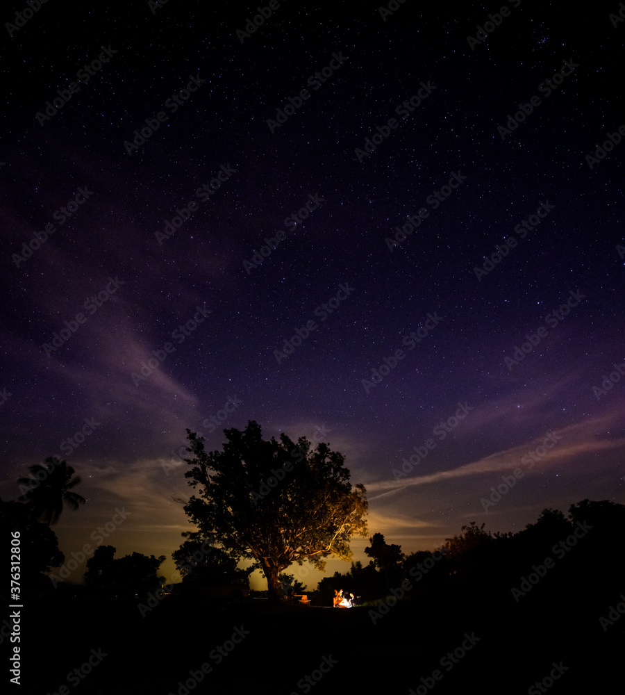 Lighting a Fire Below the Night Sky Stock Photo | Adobe Stock